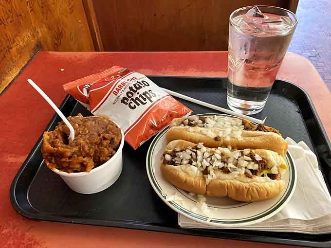 A complete meal on a tray: hot dog, beans, chips, and the kind of satisfaction that makes you understand why people become regulars.
