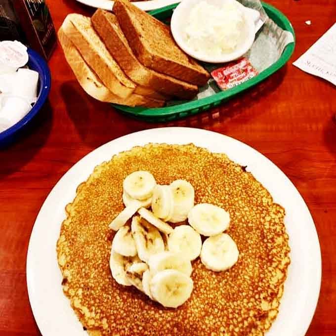 Fresh banana slices crown these golden beauties like nature's candy decorating your morning masterpiece with sweet simplicity.