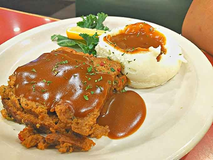 Meatloaf swimming in gravy next to mashed potatoes, looking exactly like what your soul needs after a long week.