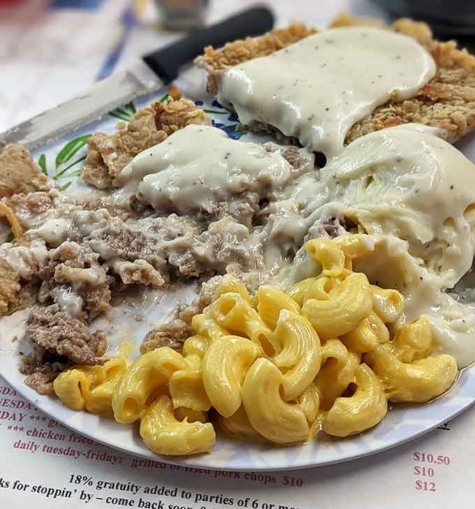 Chicken fried steak smothered in cream gravy alongside mashed potatoes and mac and cheese is pure comfort.