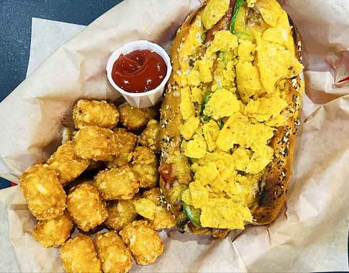 That hot dog buried under toppings is basically a flavor avalanche on a bun, and those tater tots approve.