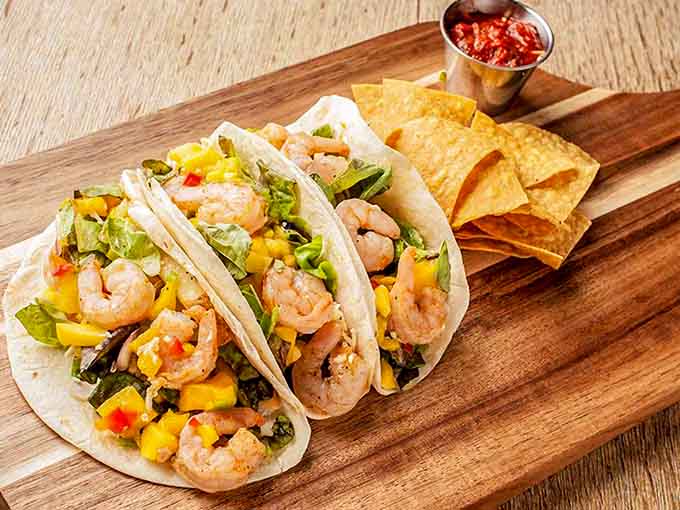 Shrimp tacos with mango salsa bring a tropical vibe to the Ozarks, proving fusion done right transcends geography.