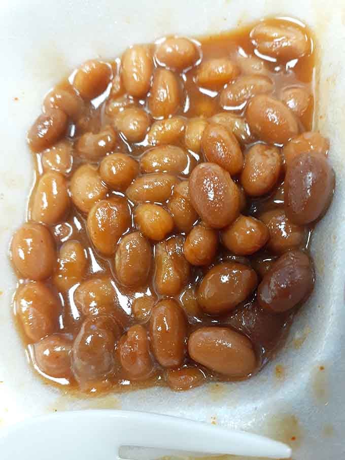 Sweet, glossy baked beans swimming in sauce that's been perfected through countless batches and happy customers.