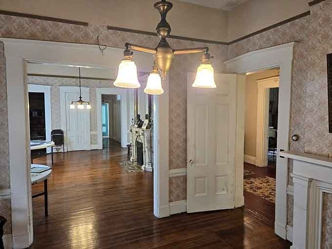 Hardwood floors gleam under period lighting, creating shadows that make you wonder if you're really alone in here after all.