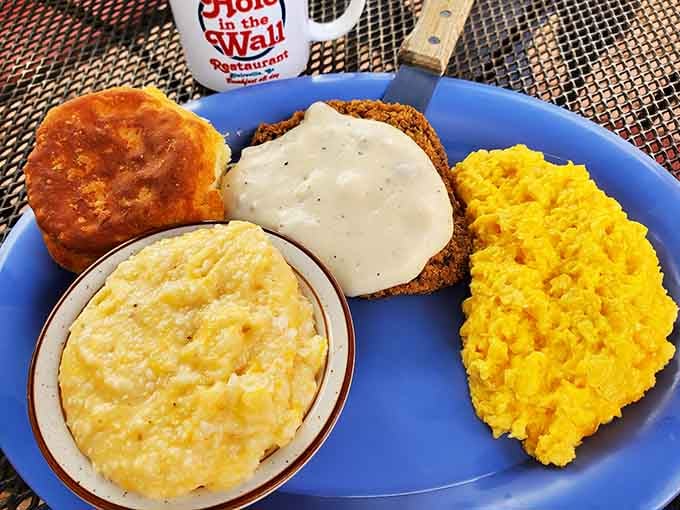 Country fried steak smothered in gravy alongside grits and a biscuit is Southern comfort at its finest.