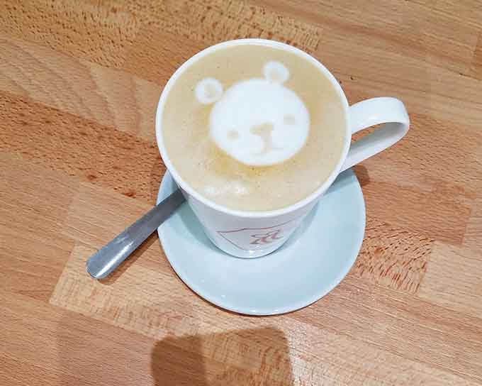 A tiny bear floats in creamy latte perfection, proving baristas here are also artists with espresso machines.