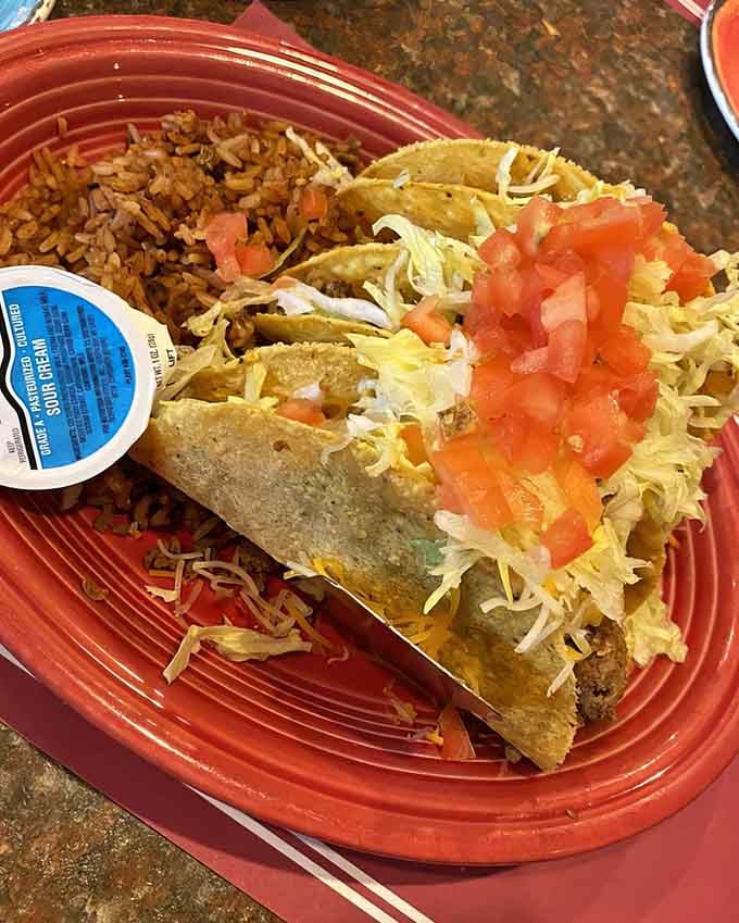 Hard shell tacos piled high with all the fixings, looking exactly like tacos should look in your happiest dreams.