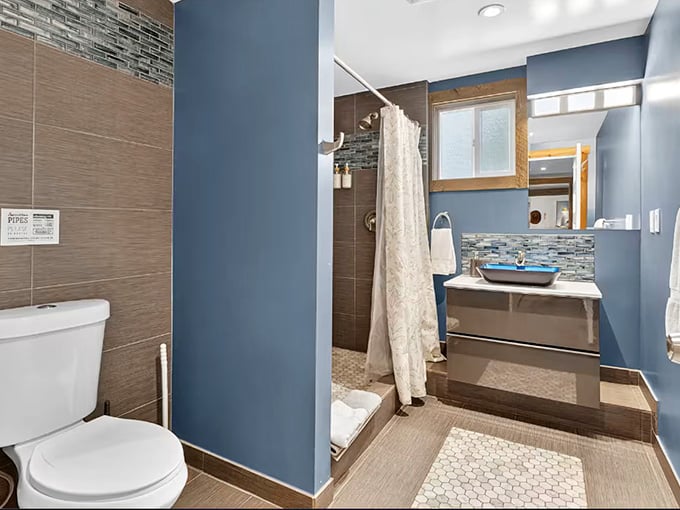 Modern tile work and calming blue walls prove that even dinosaur enthusiasts appreciate a well-designed contemporary bathroom space.