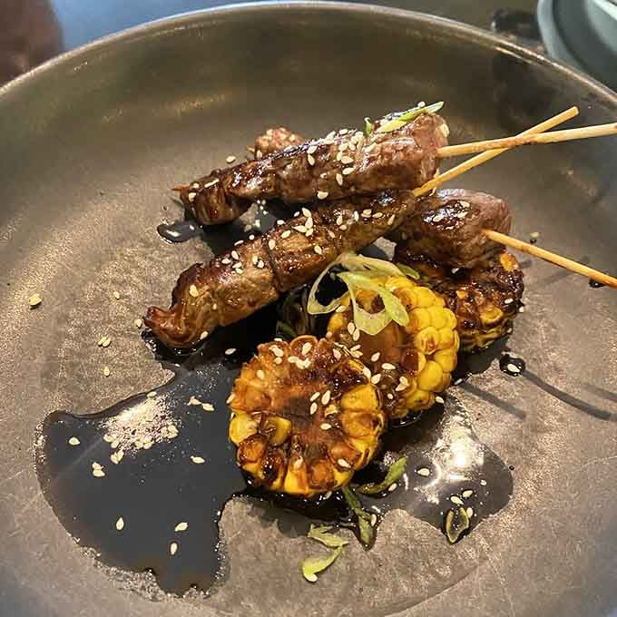 Skewers and grilled corn glisten with teriyaki glaze, making chopsticks seem suddenly inadequate for the task ahead.