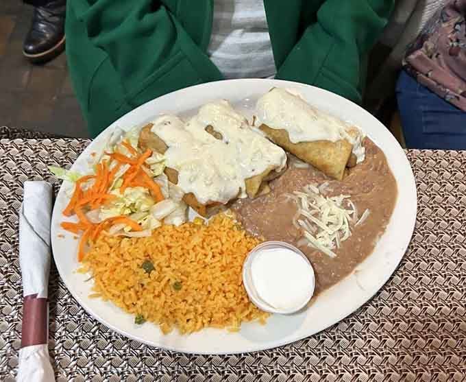 Golden chimichangas topped with creamy sauce prove that sometimes the best things in life are indeed deep-fried to perfection.