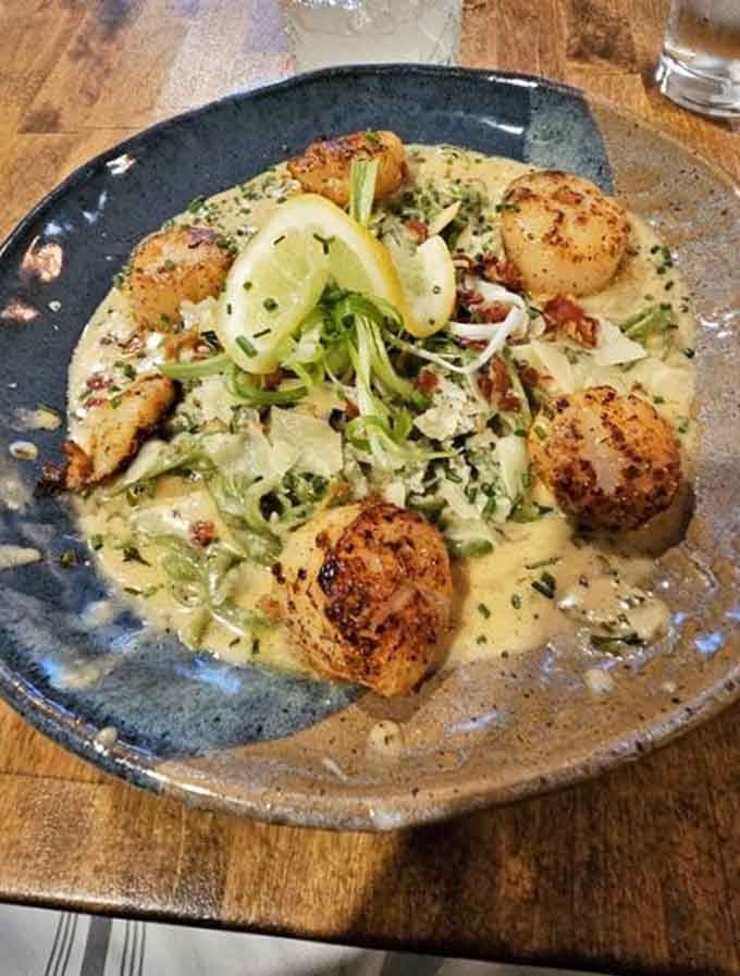 Perfectly seared scallops perched on spinach linguini like they're posing for their own cooking show debut episode tonight.