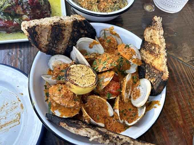 Smoke-steamed clams with crispy bread for dipping prove that sometimes the simplest preparations yield the most spectacular results.