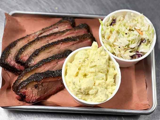 Perfectly sliced brisket lounging on butcher paper with creamy sides is the kind of simple elegance that doesn't need fancy plating to impress anyone with taste buds.