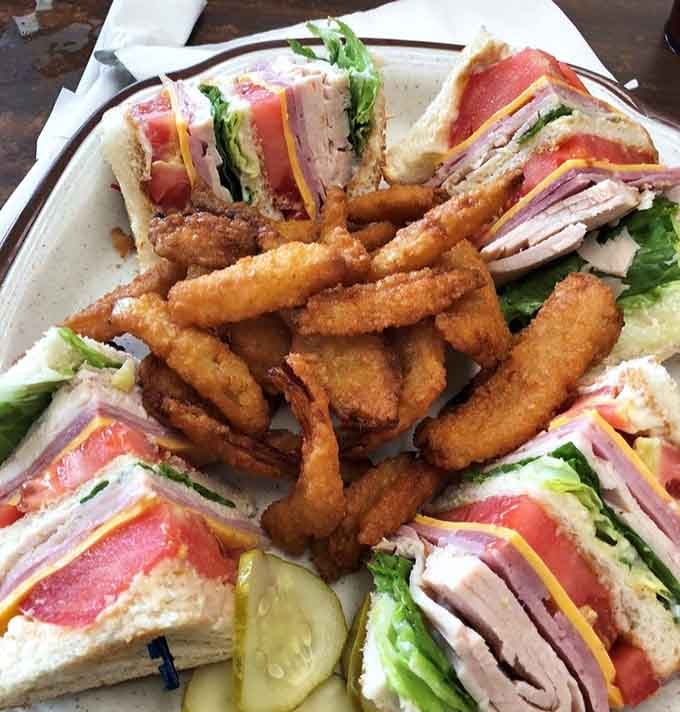 Club sandwich stacked high with turkey, ham, and crispy shrimp, because sometimes more really is more.