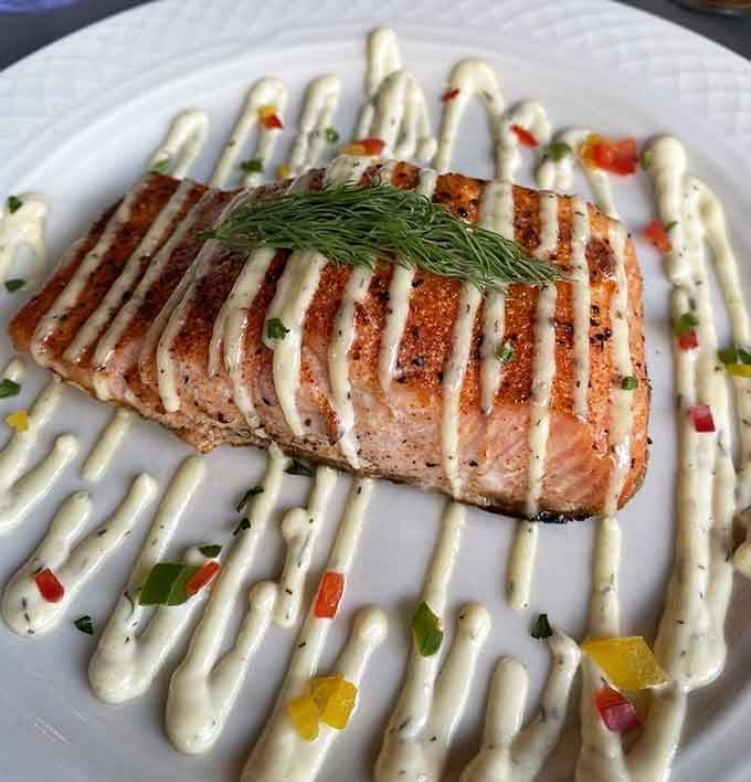 That salmon looks like it just won a beauty pageant, perfectly grilled with artistic drizzle work.