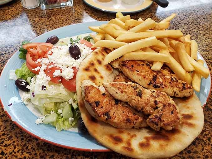 Grilled chicken souvlaki with Greek salad and fries&mdash;because sometimes you need three countries on one plate.