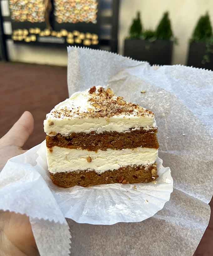 That carrot cake slice stands tall and proud, layered with enough frosting to make any dessert lover weak in the knees.