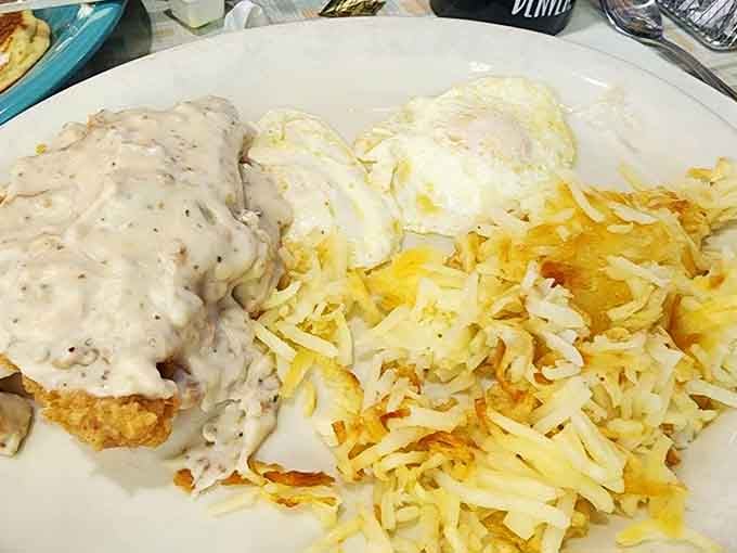 Chicken fried steak smothered in gravy alongside eggs and hash browns &ndash; breakfast doesn't get more gloriously indulgent than this.