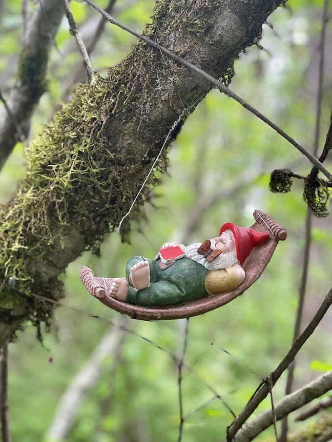This gnome's living his best life, swinging in a hammock like he just retired to the Pacific Northwest woods.