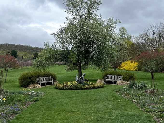 Two benches flanking a garden statue create the kind of symmetry that makes photographers weep with joy.