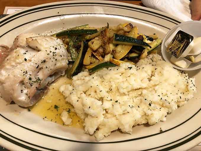 Broiled scrod with mashed potatoes and vegetables proves this kitchen handles seafood with the same care as their famous chicken.
