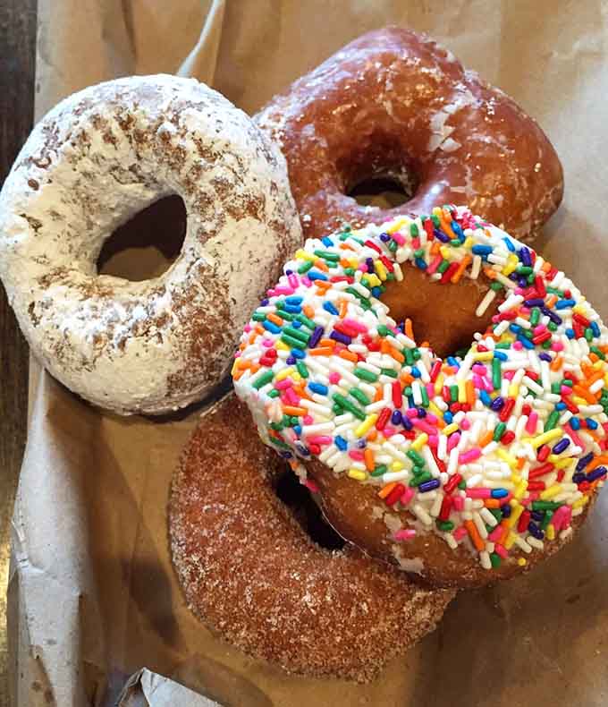 Four distinct personalities in donut form, from classic glazed to playful sprinkles and cinnamon comfort.