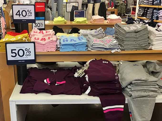 Gap clothing stacked in rainbow perfection, proving that organizing merchandise can be an art form worth photographing.