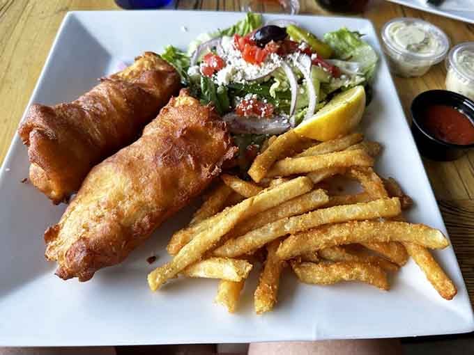 Beer-battered fish so crispy it could survive its own extinction event, served with a Greek salad.