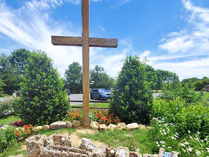 A simple wooden cross stands as a peaceful reminder of the garden's spiritual roots and purpose.