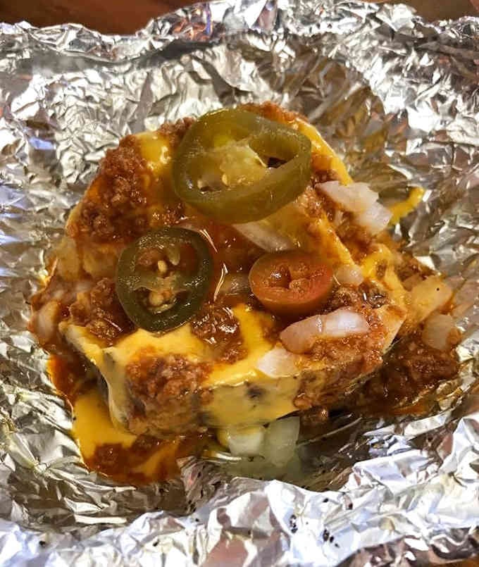 This smothered baked potato loaded with toppings proves that potatoes are the ultimate blank canvas for deliciousness and excess.