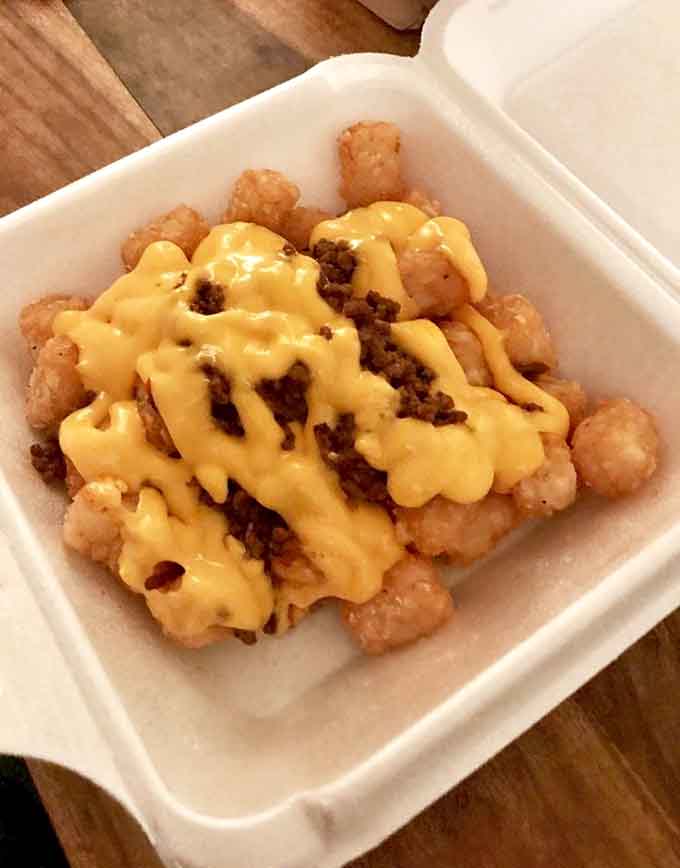 Tater tots swimming in cheese sauce: because sometimes adulting means ordering exactly what your heart wants.