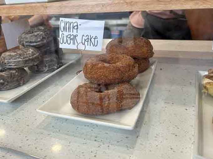 Cinna-sugar cake donuts stacked high, dusted generously, and calling your name from the display case.