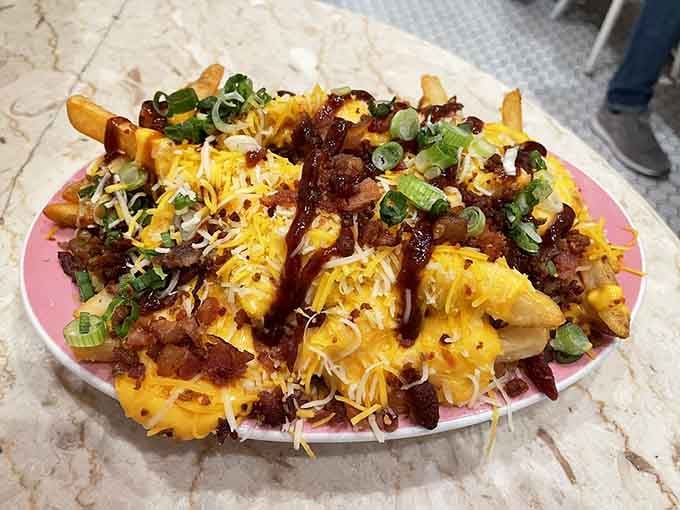 Those loaded fries buried under cheese, bacon, and scallions could feed a small army or one very determined person.