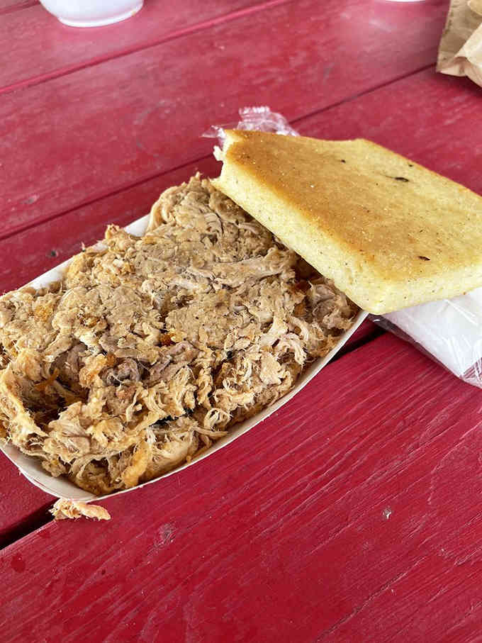 Chopped whole hog with that perfect mix of bark and tender meat, cornbread standing guard like delicious sentries.