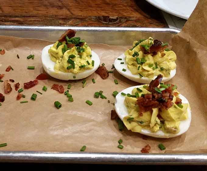 Deviled eggs get the VIP treatment with bacon and chives, proving appetizers deserve respect too.