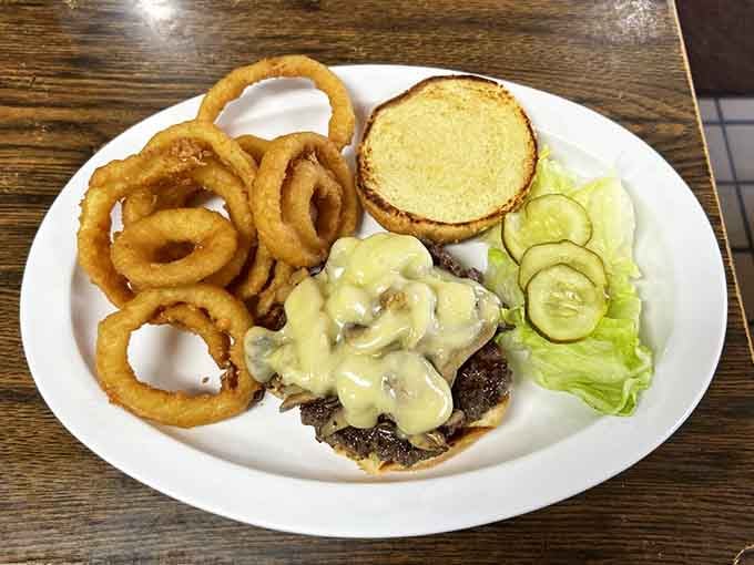 That burger knows it's special, sitting pretty with golden onion rings like edible jewelry on the side.
