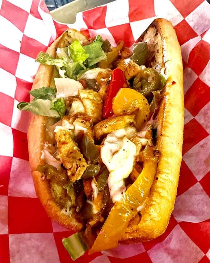That Spicy Chicken Po' Boy arrives loaded with peppers, lettuce, and enough toppings to require structural engineering expertise.