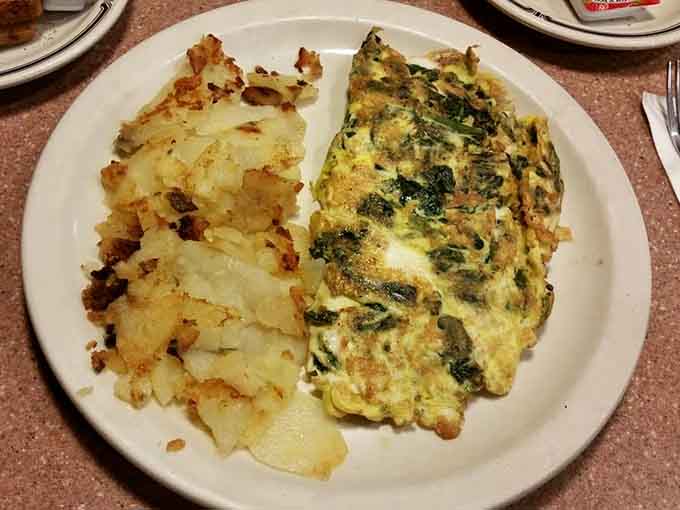 That spinach omelet looks like it's been folded by someone who actually cares, sitting next to home fries with proper golden-brown edges.