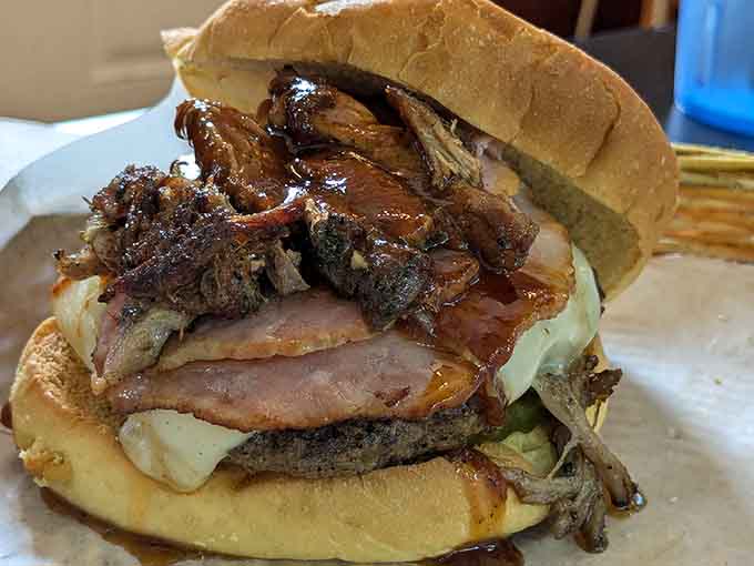 This towering creation features multiple meats piled on a bun, defying gravity and probably several laws of sandwich physics.