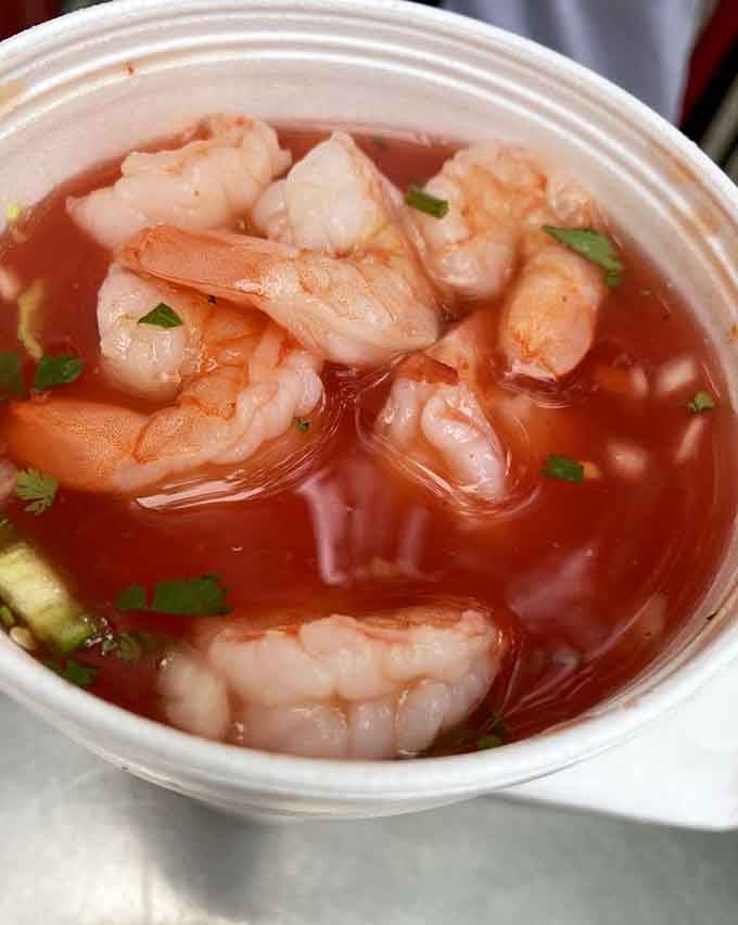 That shrimp cocktail is swimming in the kind of broth that makes you forget you're technically eating breakfast food.