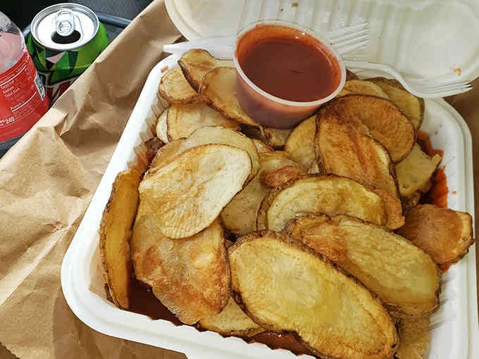 Fresh-cut chips piled high enough to require architectural support, with sauce standing by for reinforcement duty.