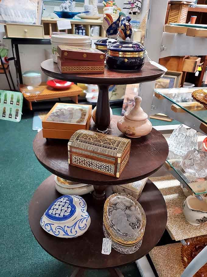 Ornate boxes and treasures stacked on wooden tiers, each container holding secrets from households and hearts long gone.