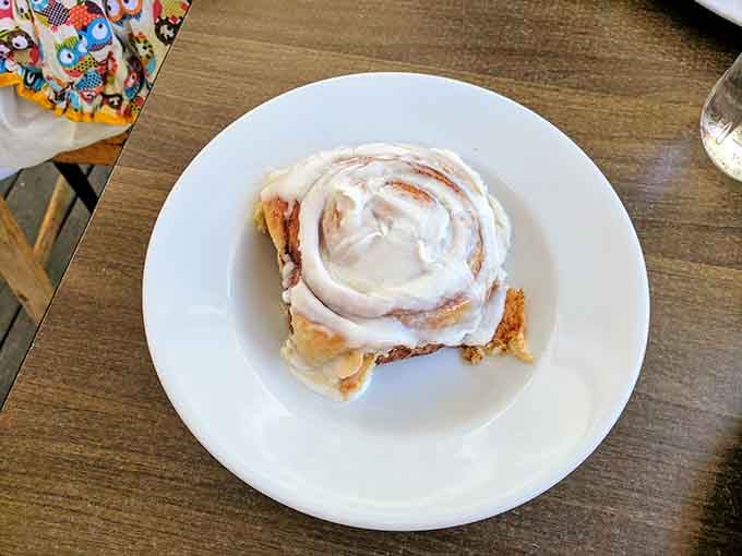 A cinnamon roll so generously frosted it makes every diet start on Monday instead of today, obviously.