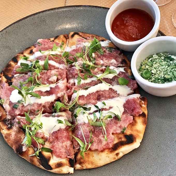 Flatbread that bridges the gap between appetizer and main course, topped with pure culinary genius.