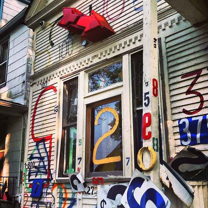 Numbers dance across weathered siding like a mathematical fever dream that somehow makes perfect artistic sense.