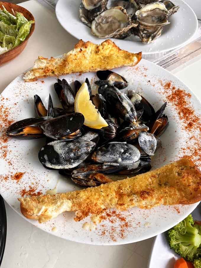 Mussels served with garlic toast because someone in that kitchen understands that sopping up broth is mandatory, not optional.