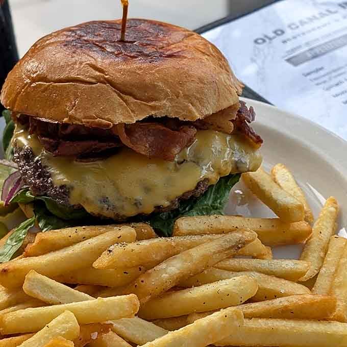 A burger stacked high with bacon and cheese, proving that sometimes simple pleasures are the most satisfying ones.