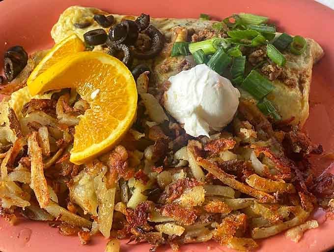 Hash browns so crispy they could double as edible architecture, topped with an omelet that means business.