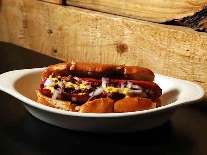 Mustard, onions, and a perfectly grilled frank create a hot dog experience worthy of its own standing ovation.