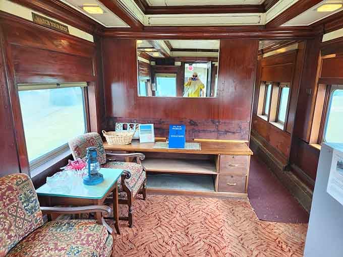 An office car interior showcasing the kind of workspace that made business travel actually civilized, complete with proper furniture and natural light.